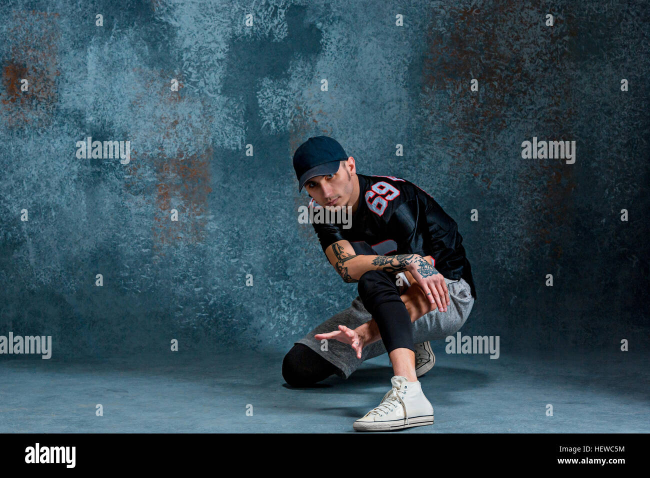 Young man break dancing on blue studio background Stock Photo - Alamy