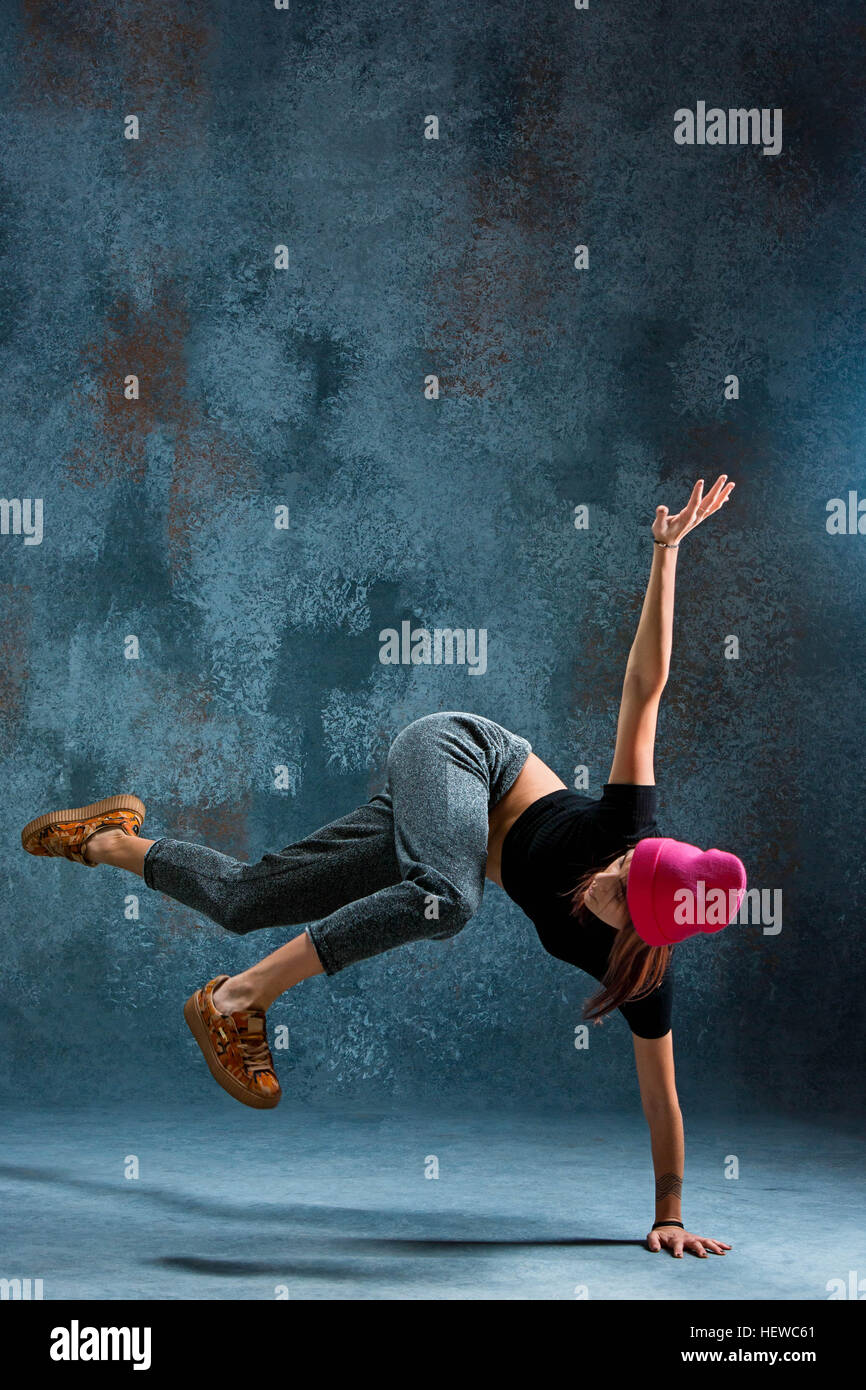 Young girl break dancing on blue studio background Stock Photo - Alamy