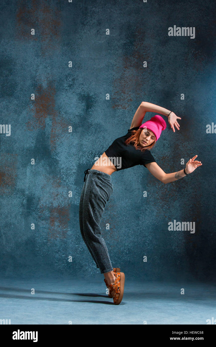 Young girl break dancing on blue studio background Stock Photo - Alamy