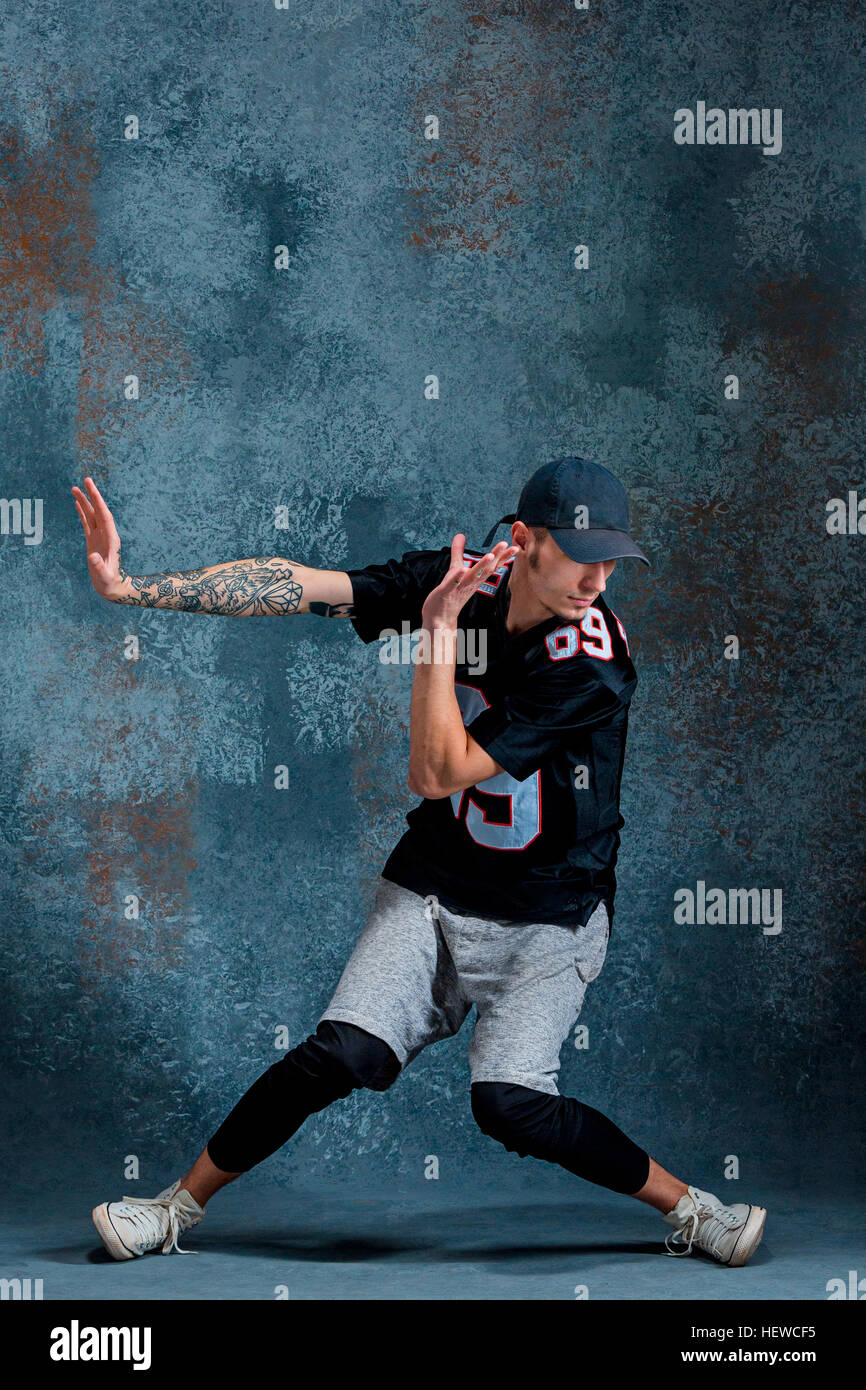 Young man break dancing on blue studio background Stock Photo - Alamy