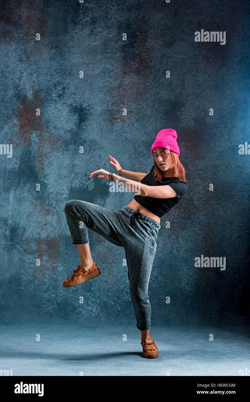 Young girl break dancing on blue studio background Stock Photo - Alamy