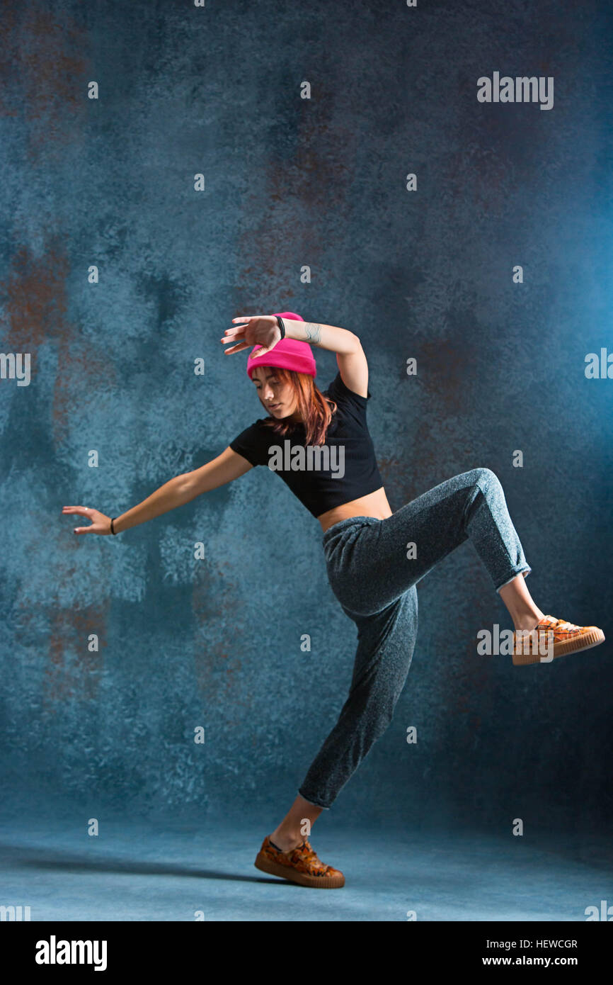 Young girl break dancing on blue studio background Stock Photo - Alamy