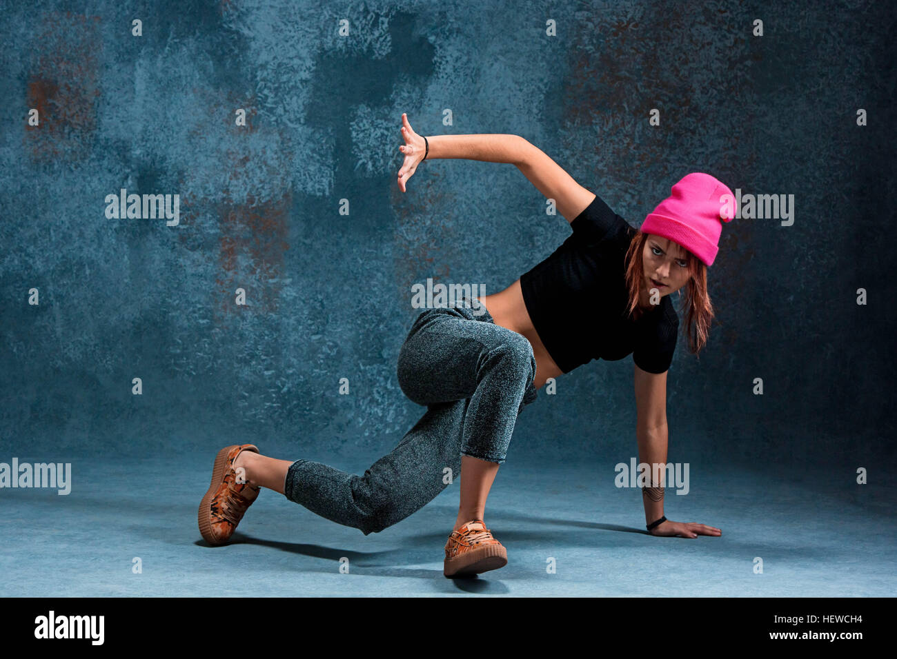 Young girl break dancing on blue studio background Stock Photo - Alamy