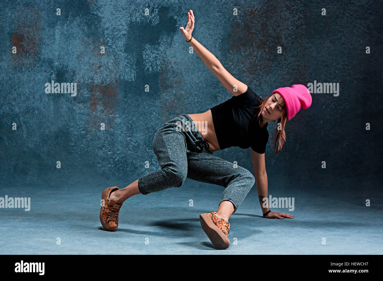 Young girl break dancing on blue studio background Stock Photo - Alamy