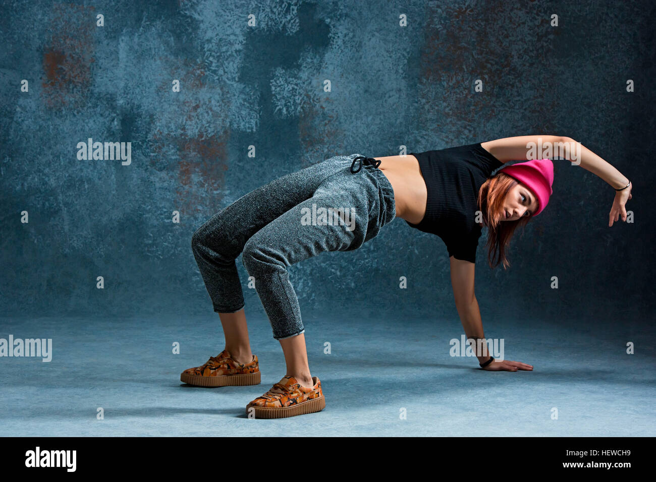 Young girl break dancing on blue studio background Stock Photo - Alamy