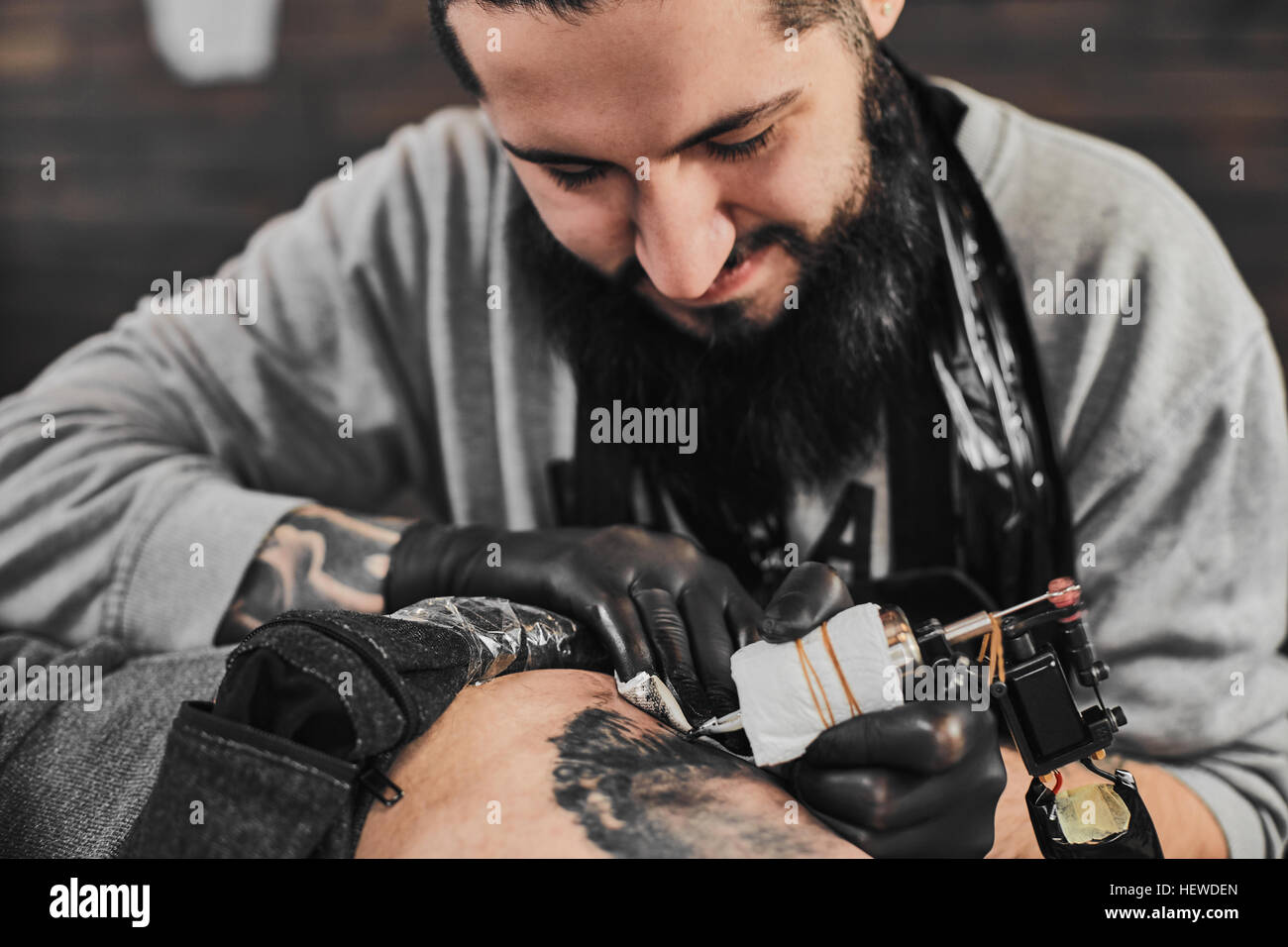 Tattoo master is tattooing in the tattoosalon Stock Photo - Alamy