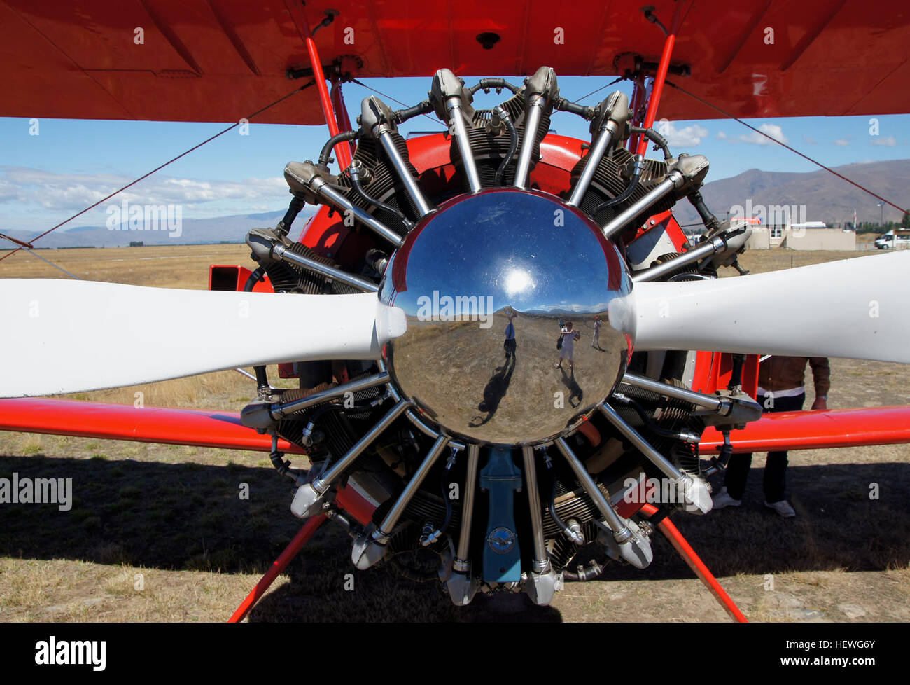 This image captures a red biplane in flight, showcasing the aircraft’s ...