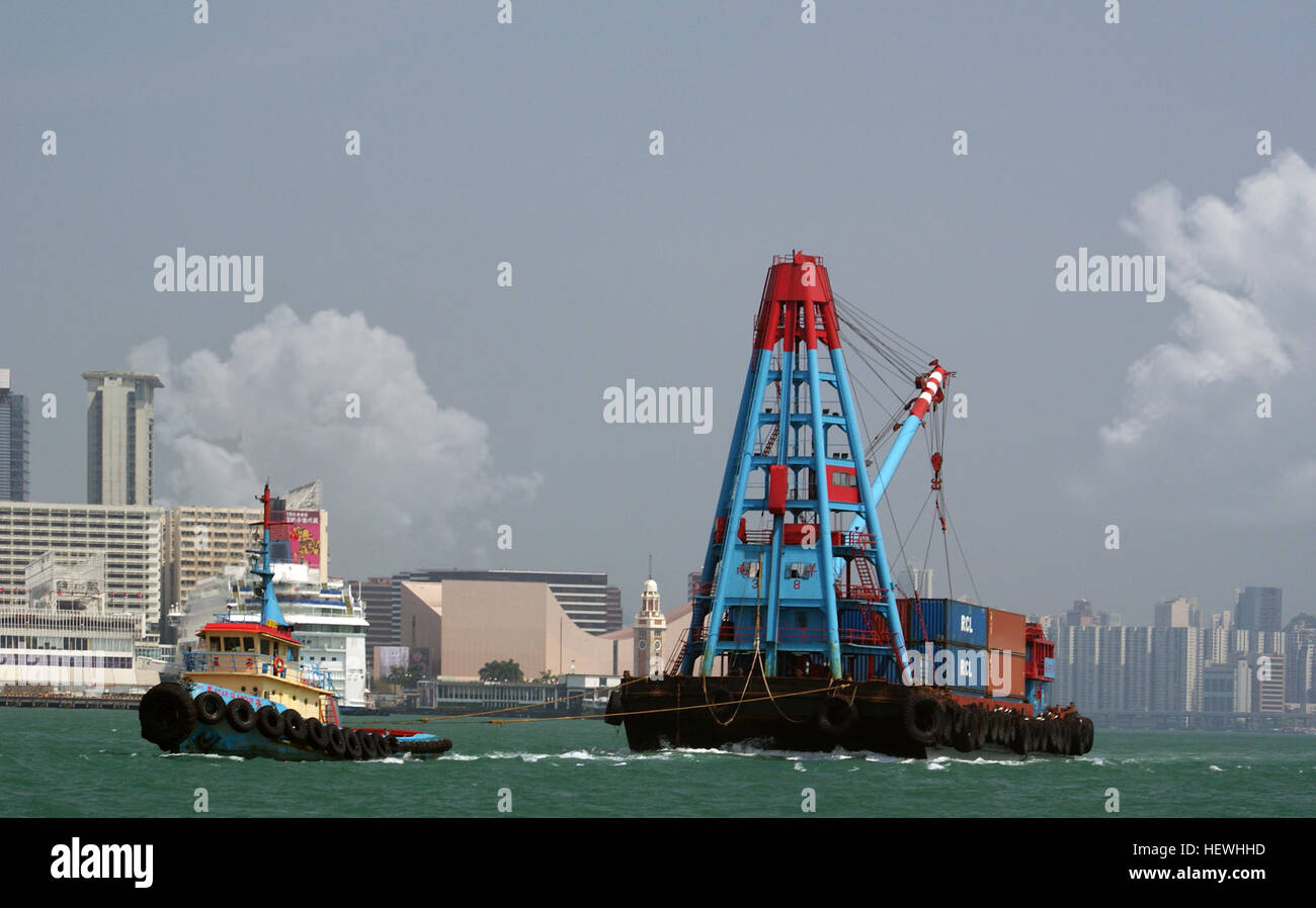 This image captures a tug boat towing a barge in Victoria Harbour, Hong ...