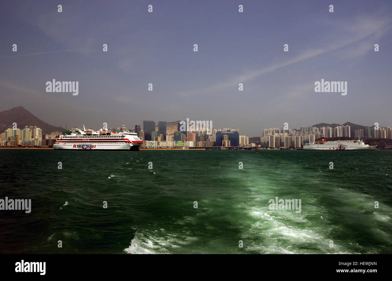 A cruise ship and ferries create boat wakes in Hong Kong Harbour, a ...
