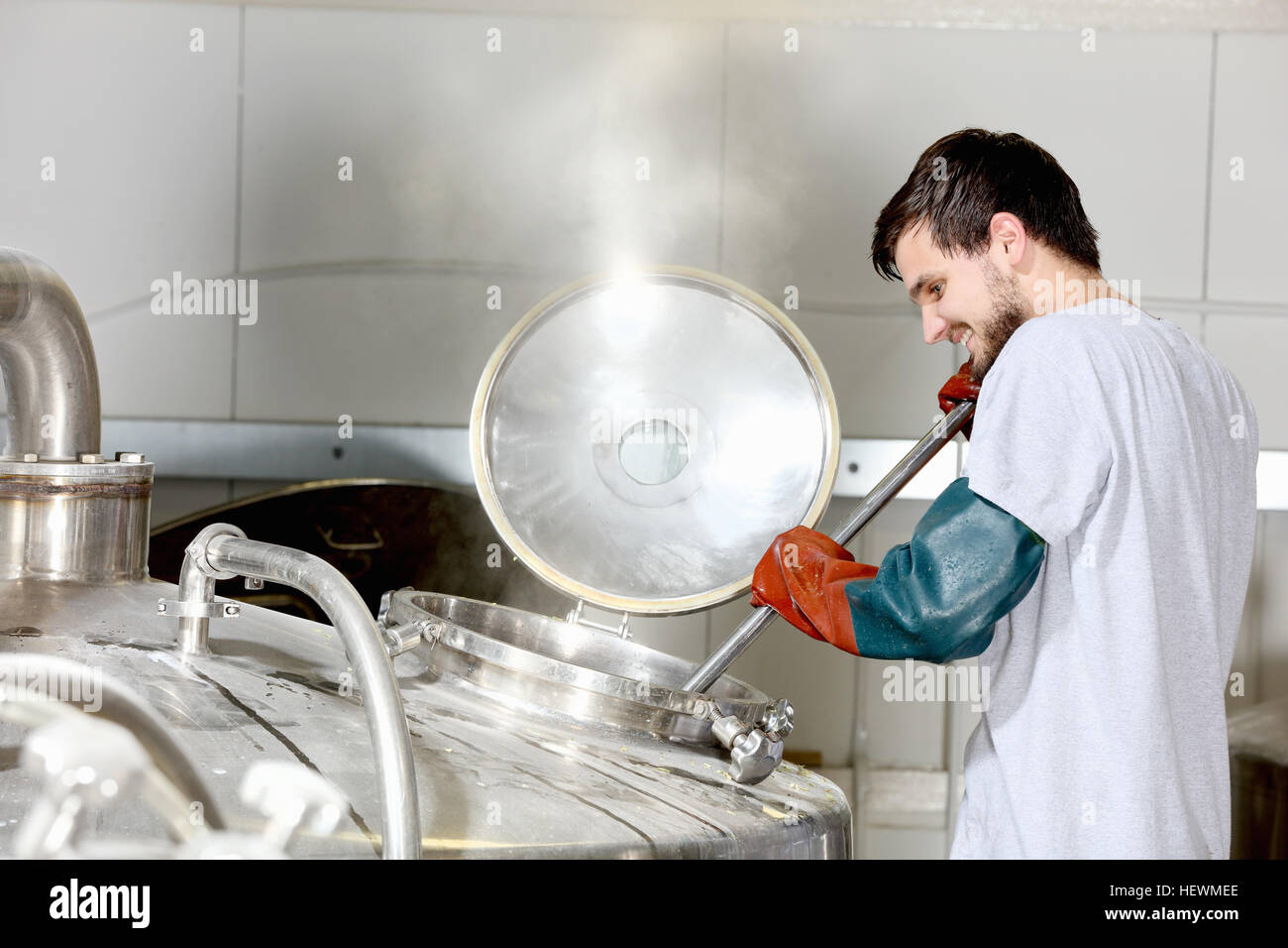 Worker in brewery, adding hops to brew kettle Stock Photo - Alamy