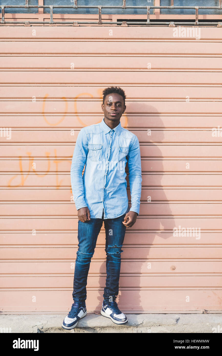 Full length portrait of man in front of shutters Stock Photo - Alamy