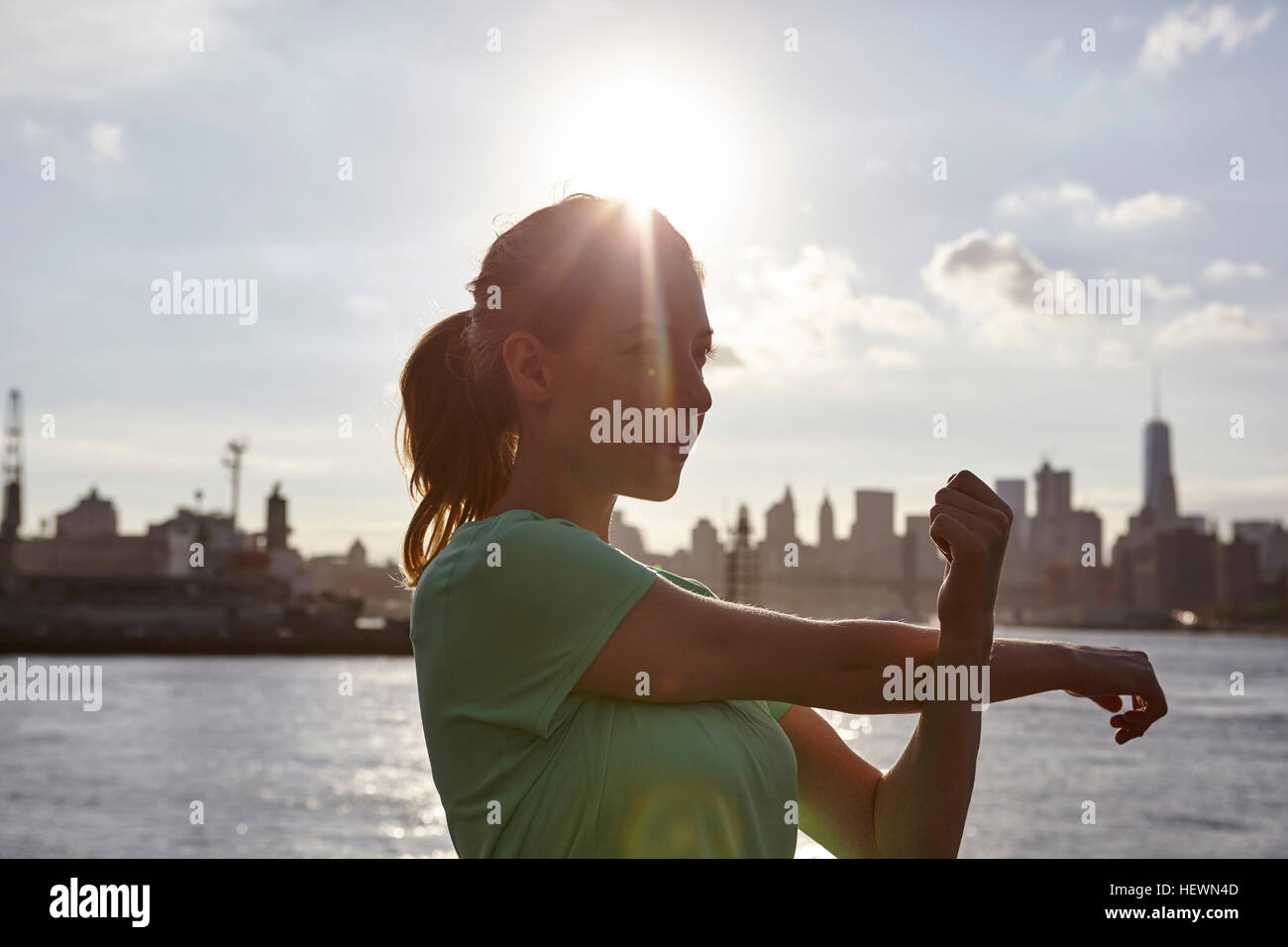 Woman by water stretching arm, Manhattan, New York, USA Stock Photo - Alamy