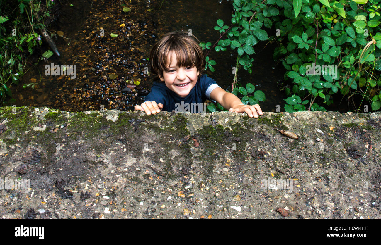 Boy climbing over wall hi-res stock photography and images - Alamy