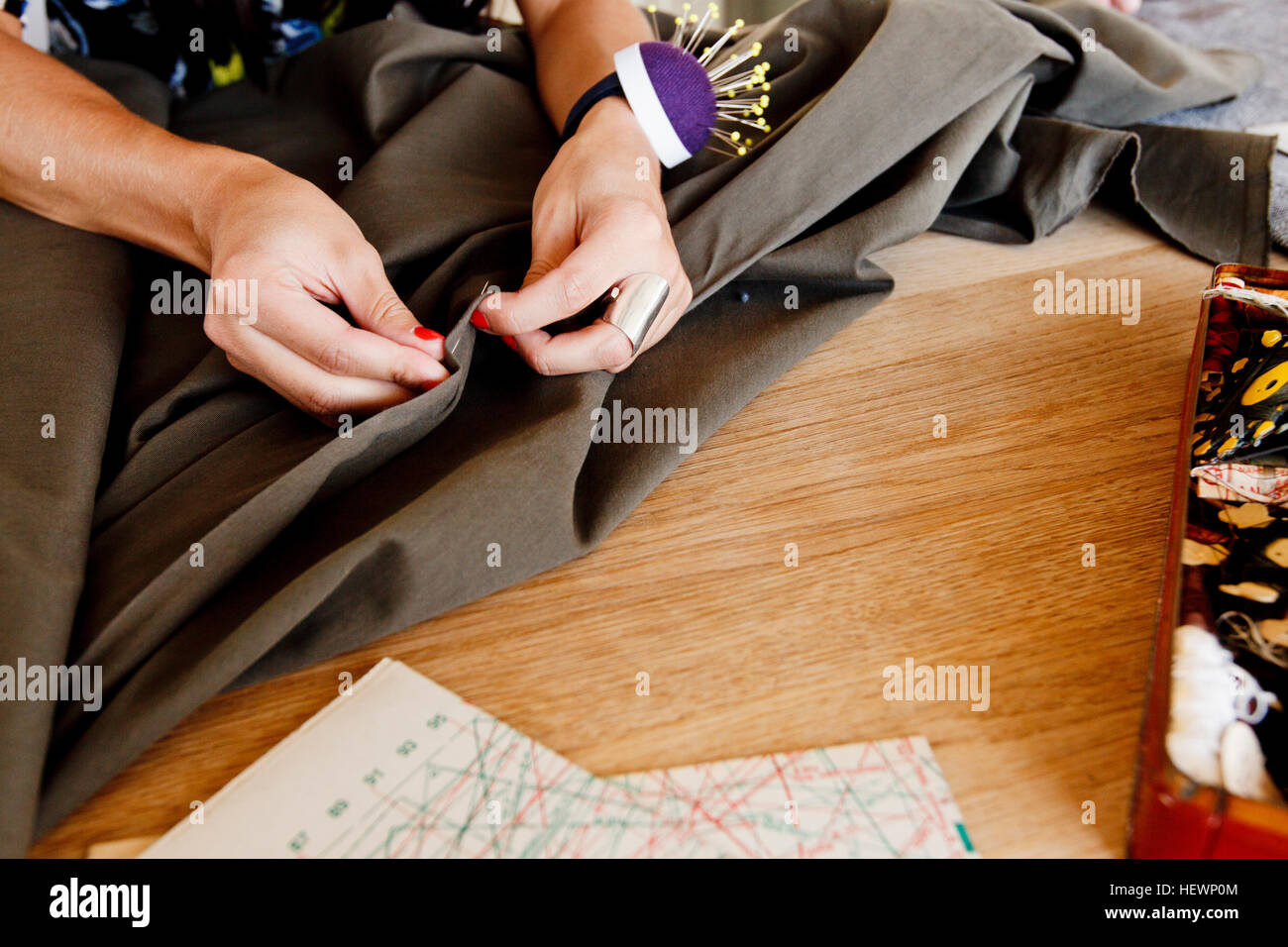 Cropped view of seamstress pinning fabric Stock Photo - Alamy