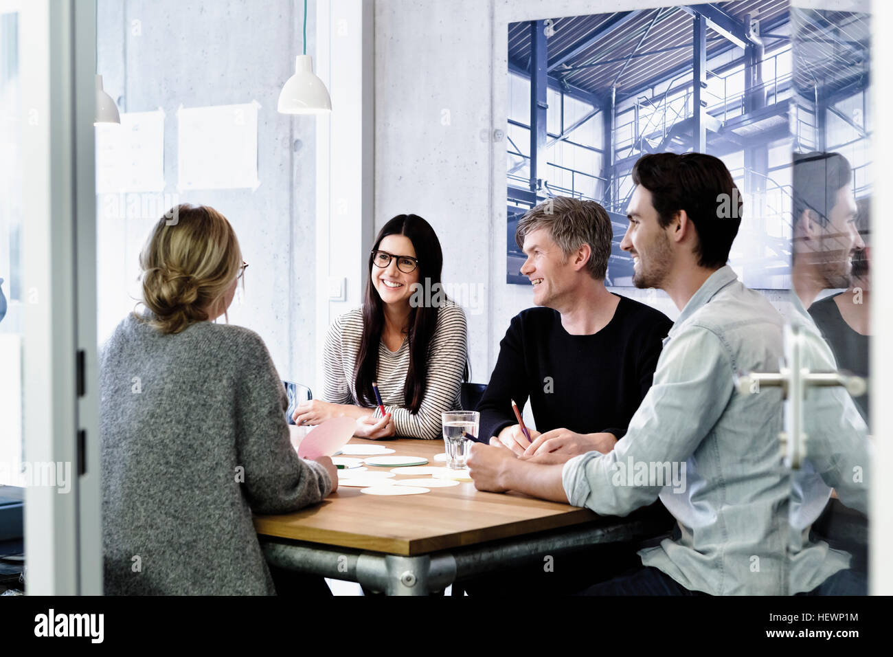 Colleagues at meeting in conference room smiling Stock Photo - Alamy