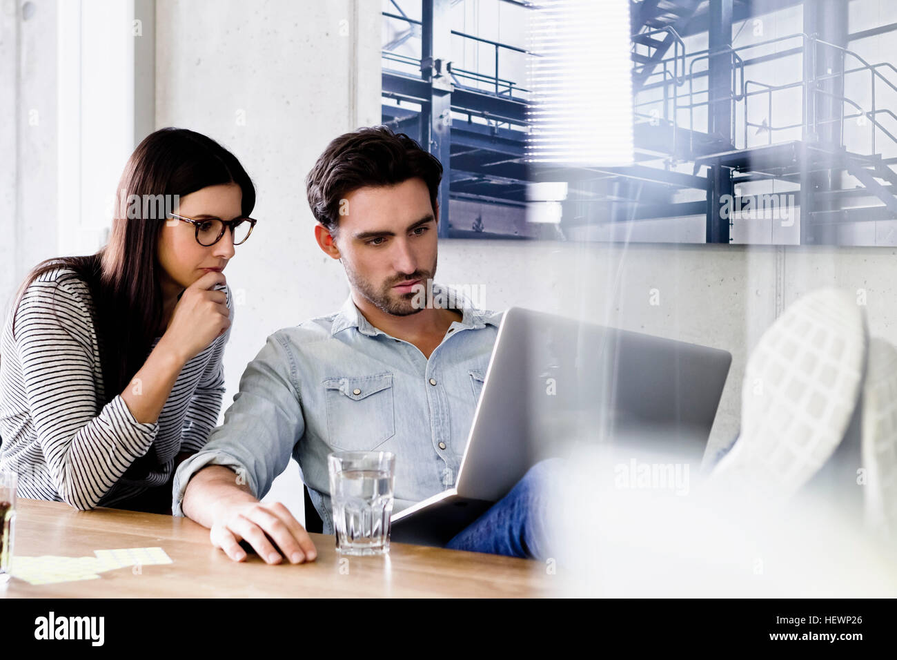 Colleagues in office using laptop Stock Photo - Alamy