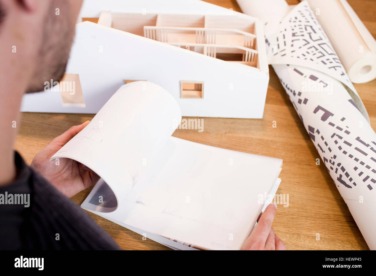 Over shoulder view of architect looking at book Stock Photo - Alamy