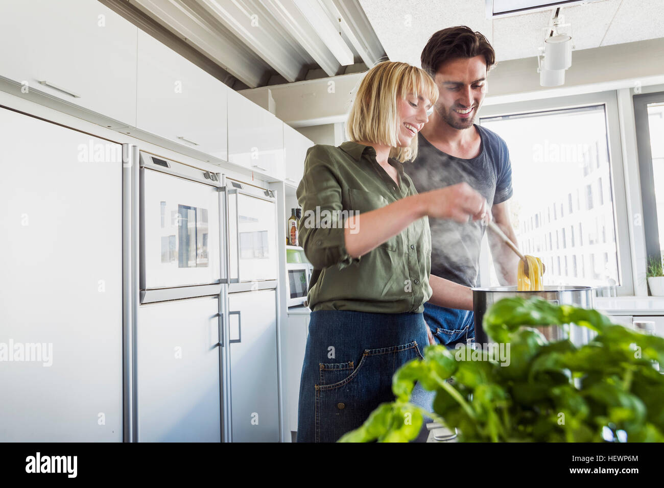 Couple in kitchen cooking pasta Stock Photo - Alamy