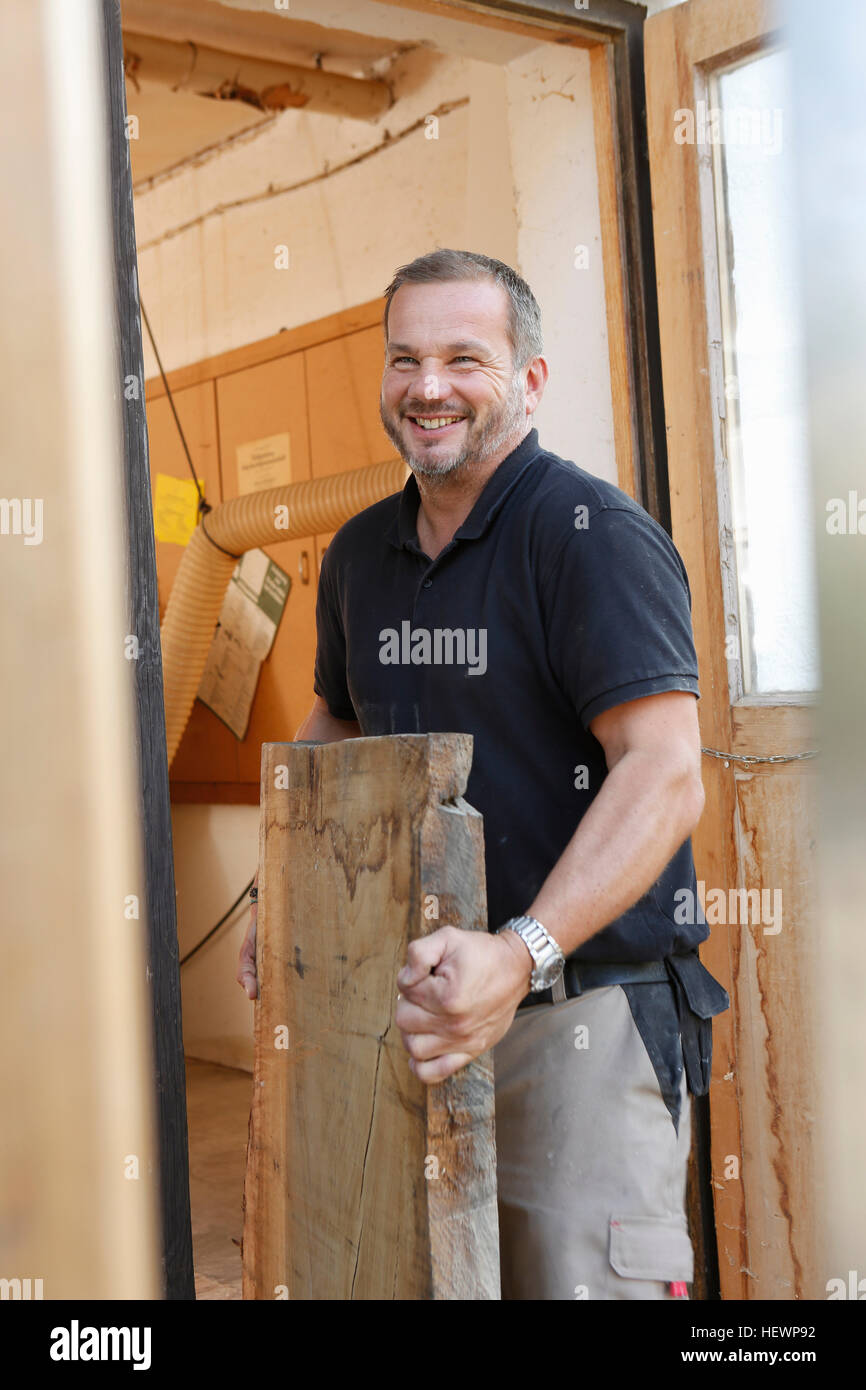 Man carrying timber Stock Photo - Alamy
