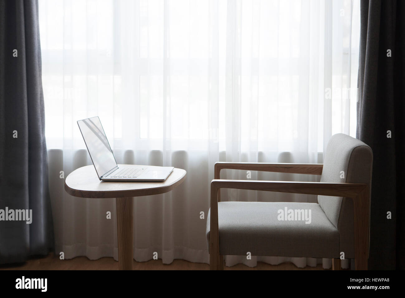 Laptop on desk with chair, in front of window Stock Photo - Alamy