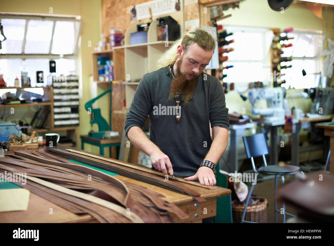 Male worker in leather workshop, measuring leather Stock Photo - Alamy