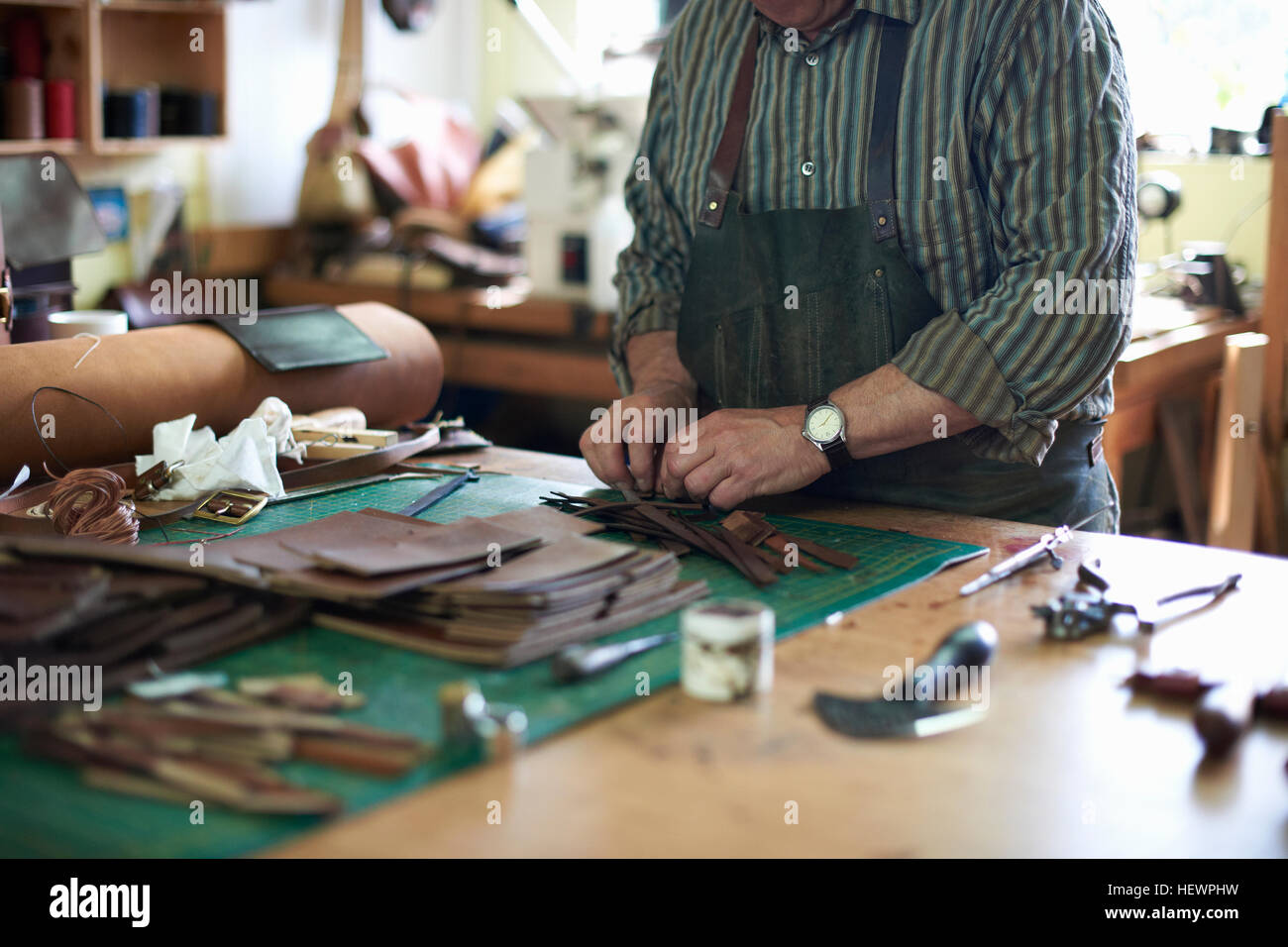Male worker in leather workshop, arranging leather, mid section Stock ...
