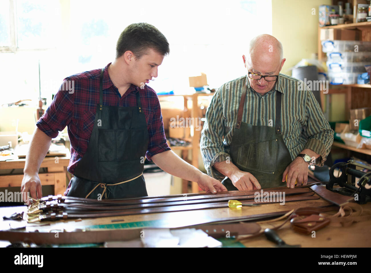 Two male workers in leather workshop, checking leather belts Stock ...