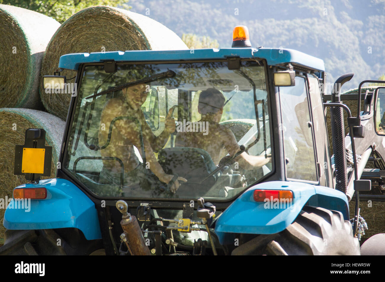 Harvesting tractor stacking circular haystacks Stock Photo - Alamy
