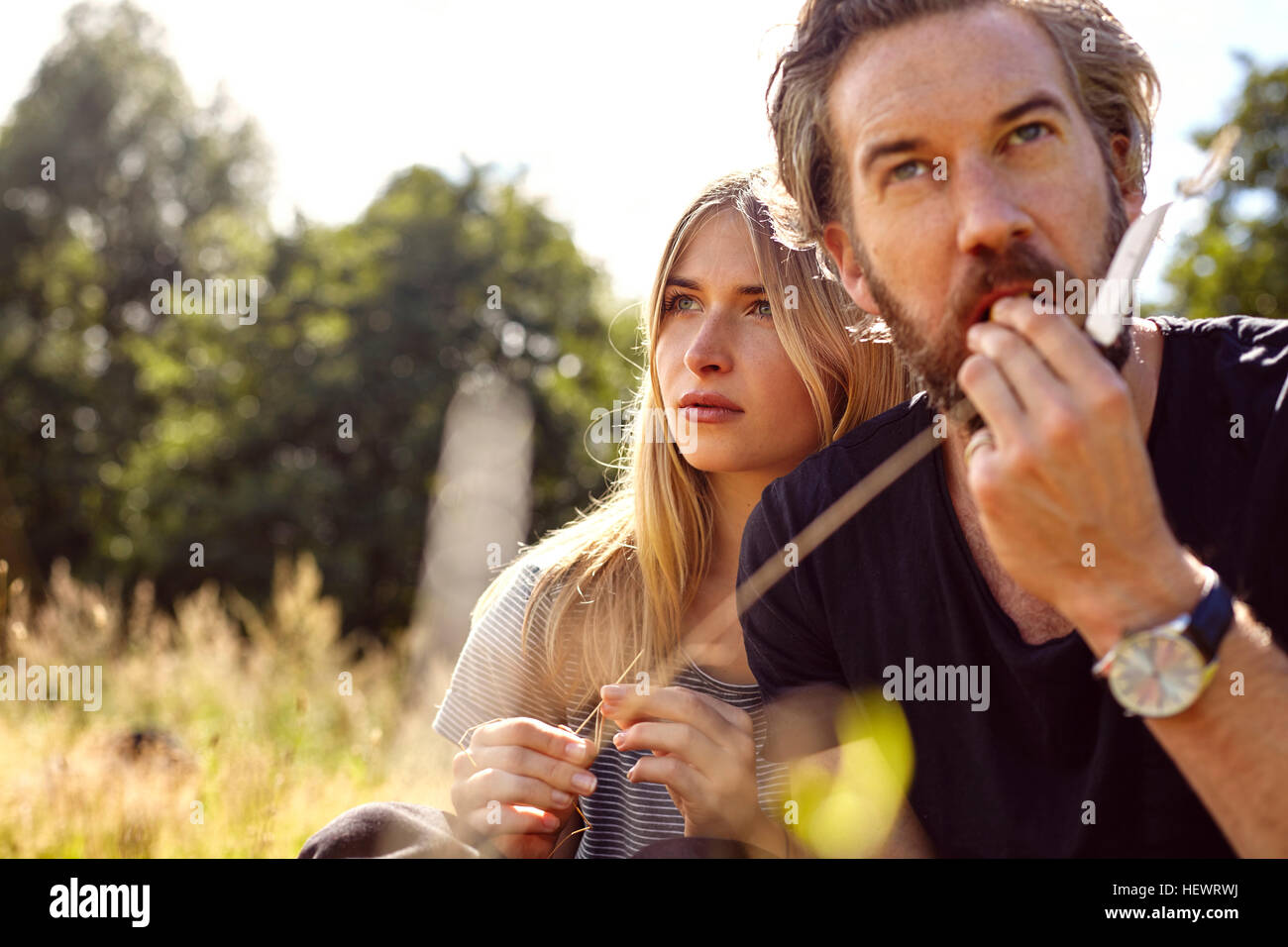Couple eating whilst sitting in rural field Stock Photo - Alamy