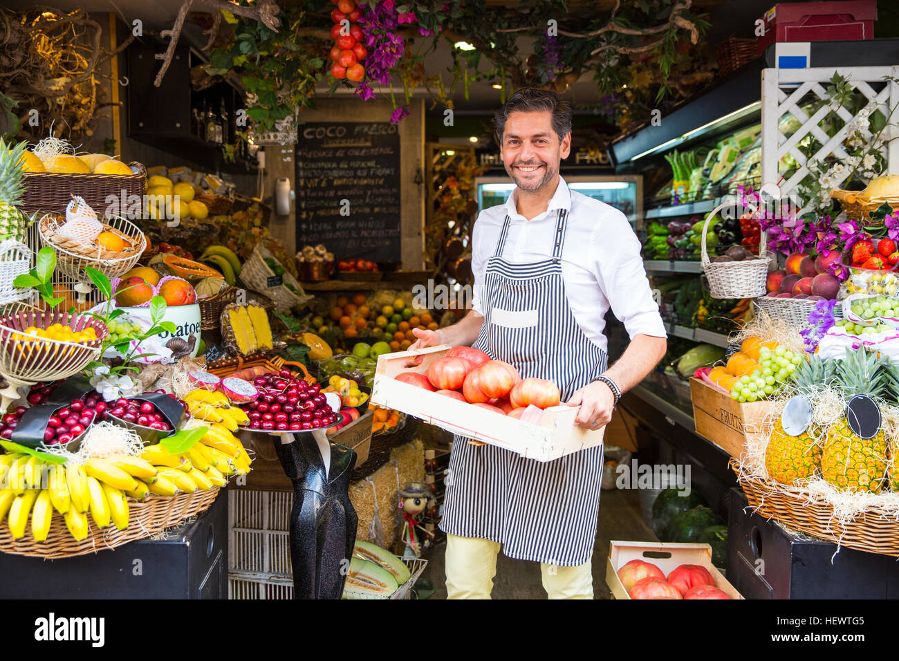 Fruiterer carrying tray of fruits in shop, Palma de Mallorca, Spain ...