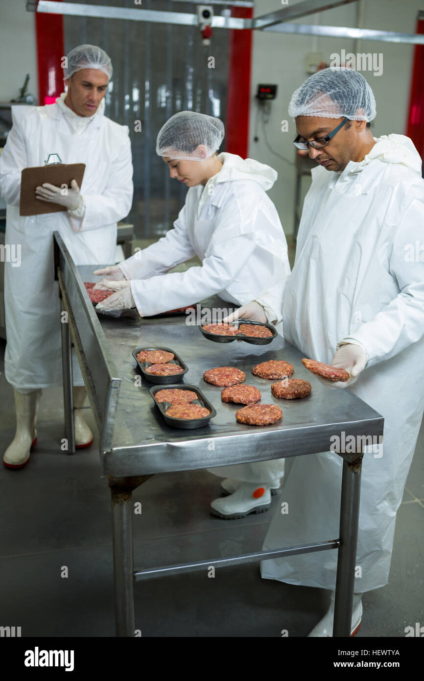Butchers packaging hamburger patty at meat factory Stock Photo - Alamy