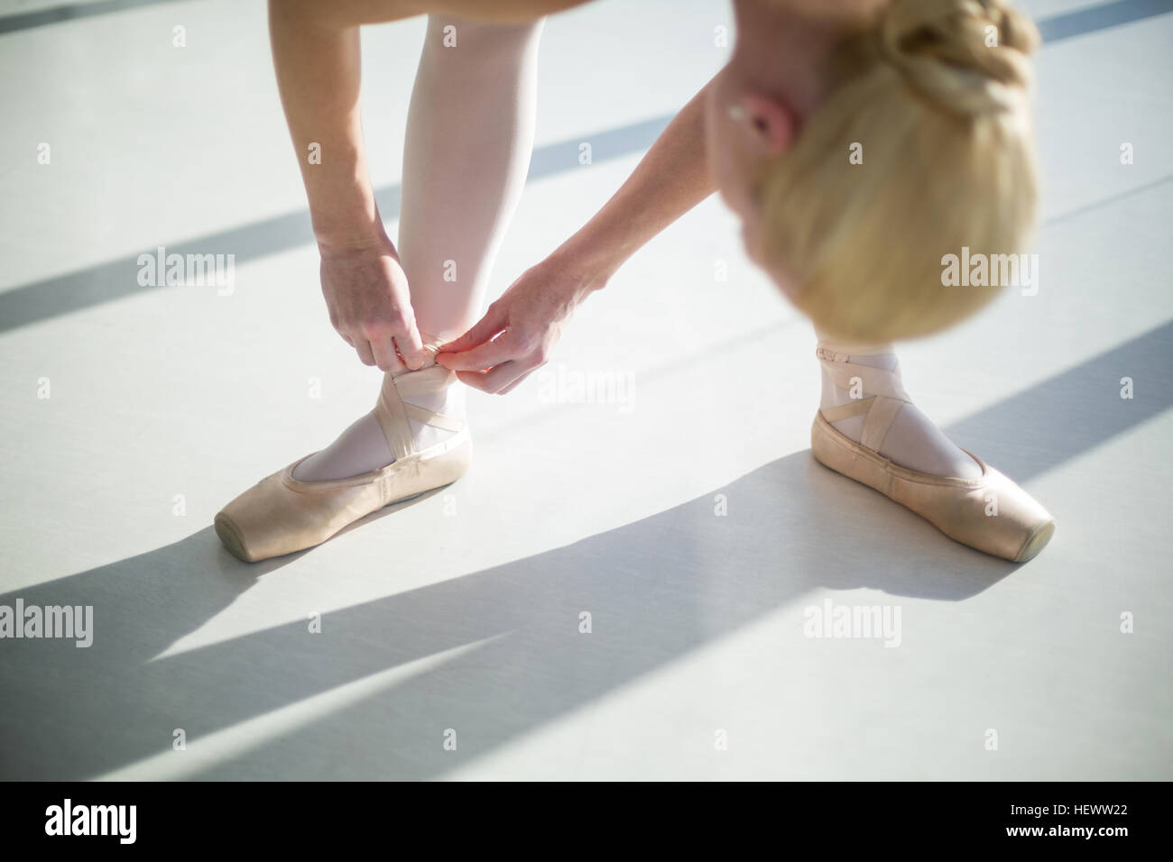 Ballerina tying her ballet shoes in the studio Stock Photo - Alamy