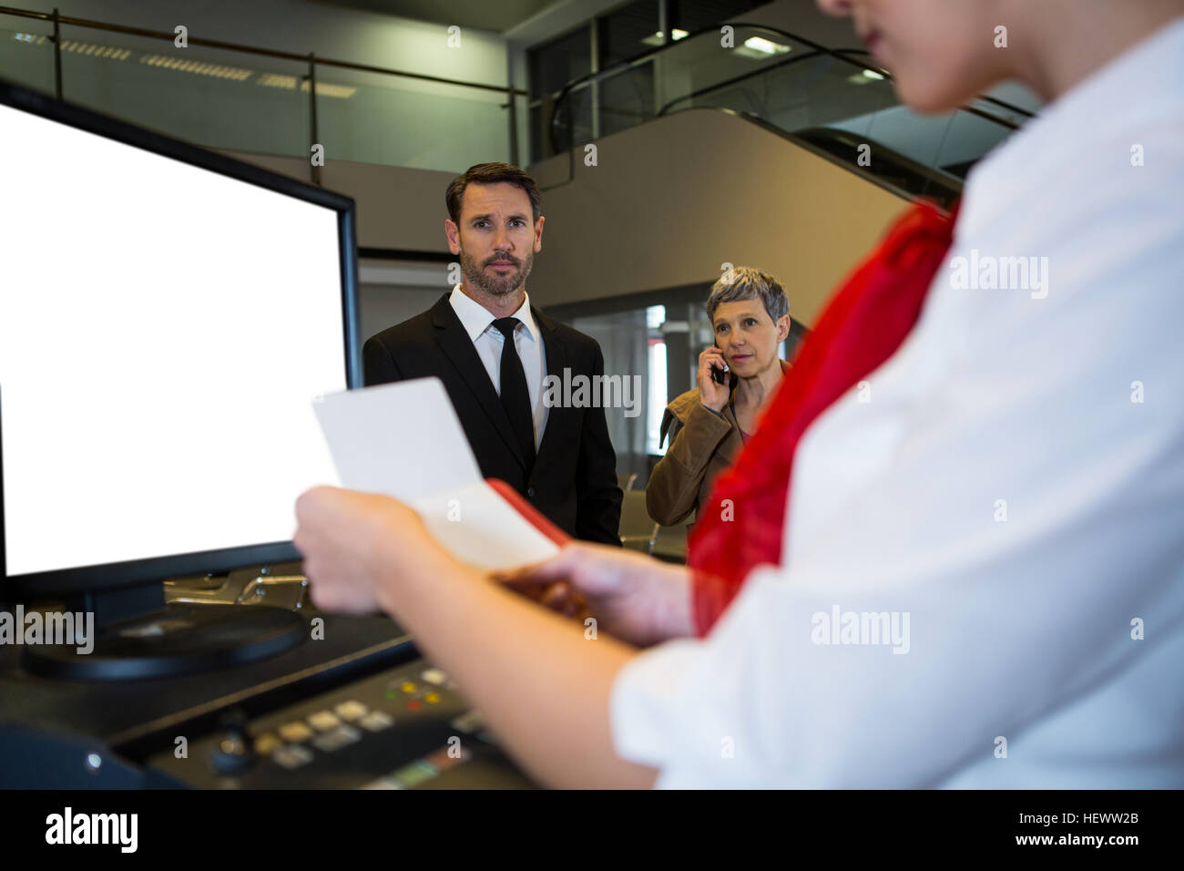 Close-up of female staff checking boarding pass with passenger in ... Close-up of female staff checking boarding pass with passenger in ...