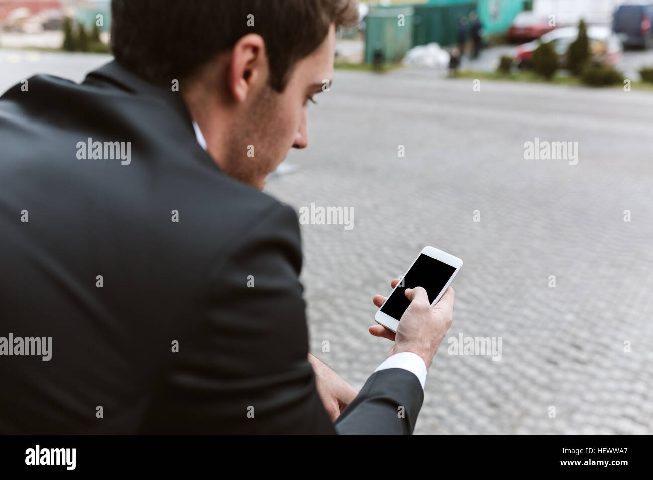 Back view of business man in suit with phone outdoors Stock Photo - Alamy