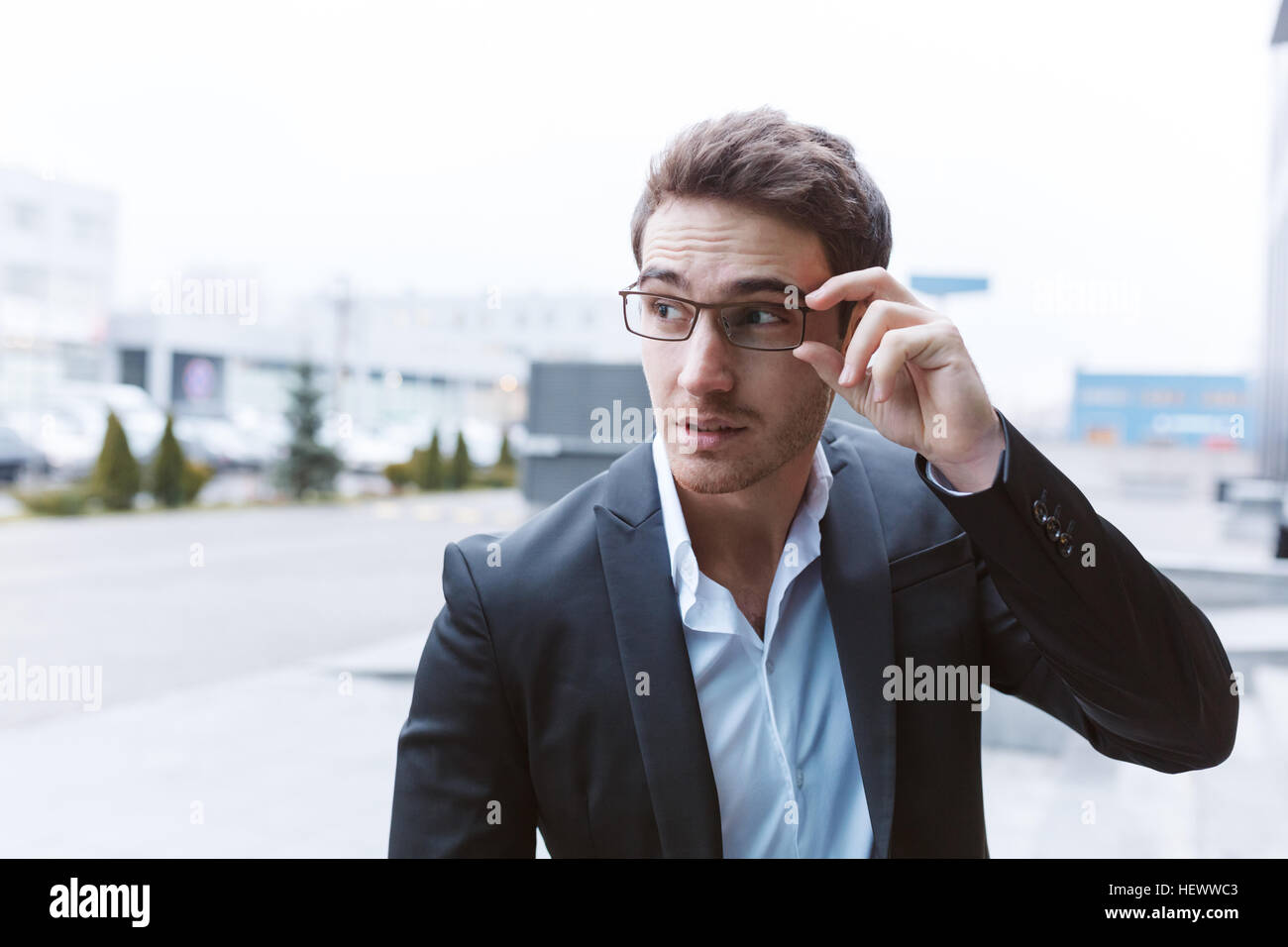 Cool Business man in suit and glasses standing on the street, holding ...