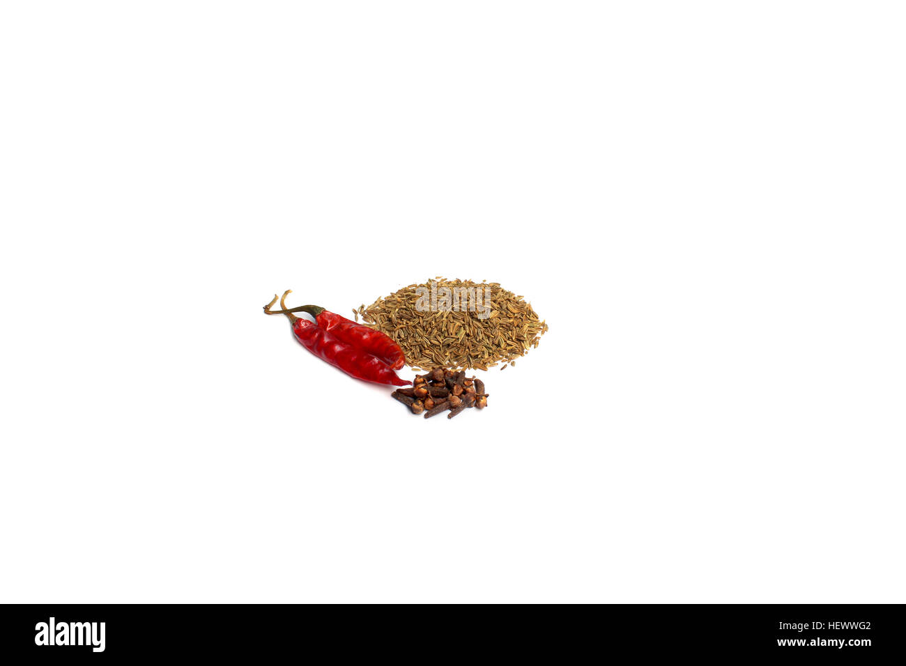 Cumin seeds, red challis and cloves over white background Stock Photo ...