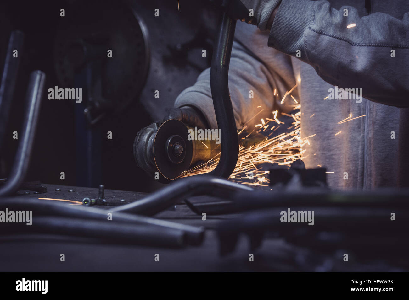 Man sawing metal with a rotary angle grinder on an aluminium surface ...