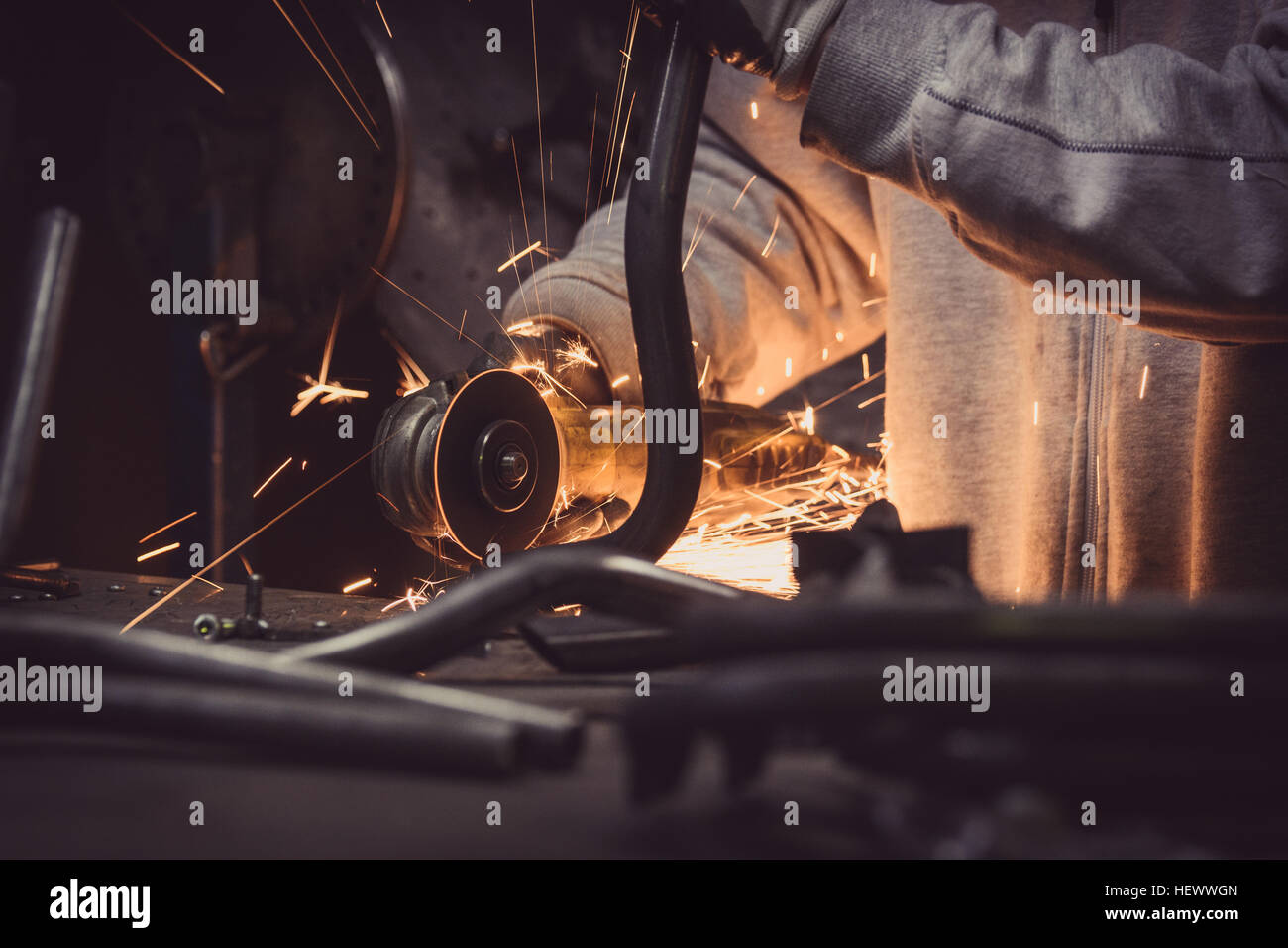 Man sawing metal with a rotary angle grinder on an aluminium surface ...