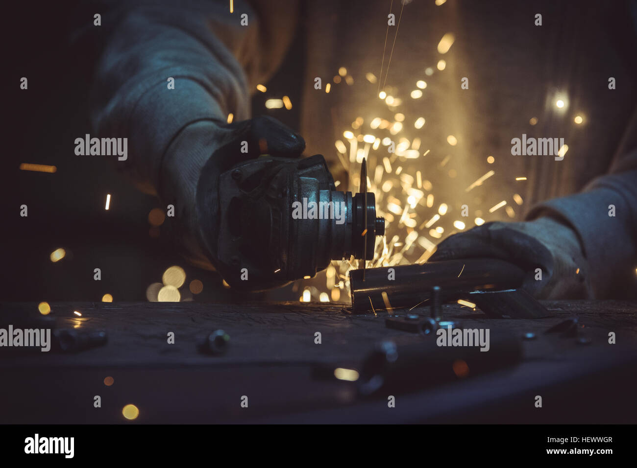 Man sawing metal with a rotary angle grinder on an aluminium surface ...