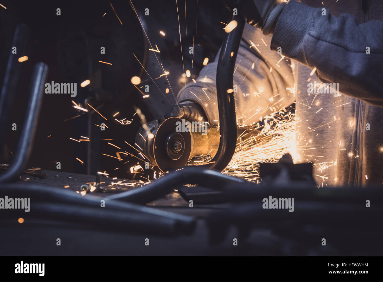 Man sawing metal with a rotary angle grinder on an aluminium surface ...