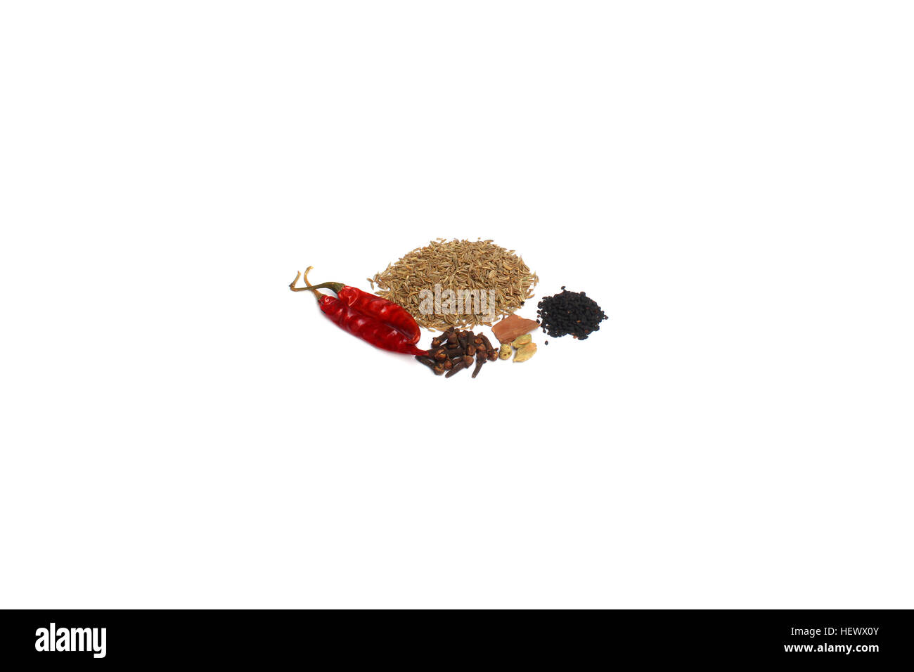 Cumin seeds, red challis and cloves over white background Stock Photo ...
