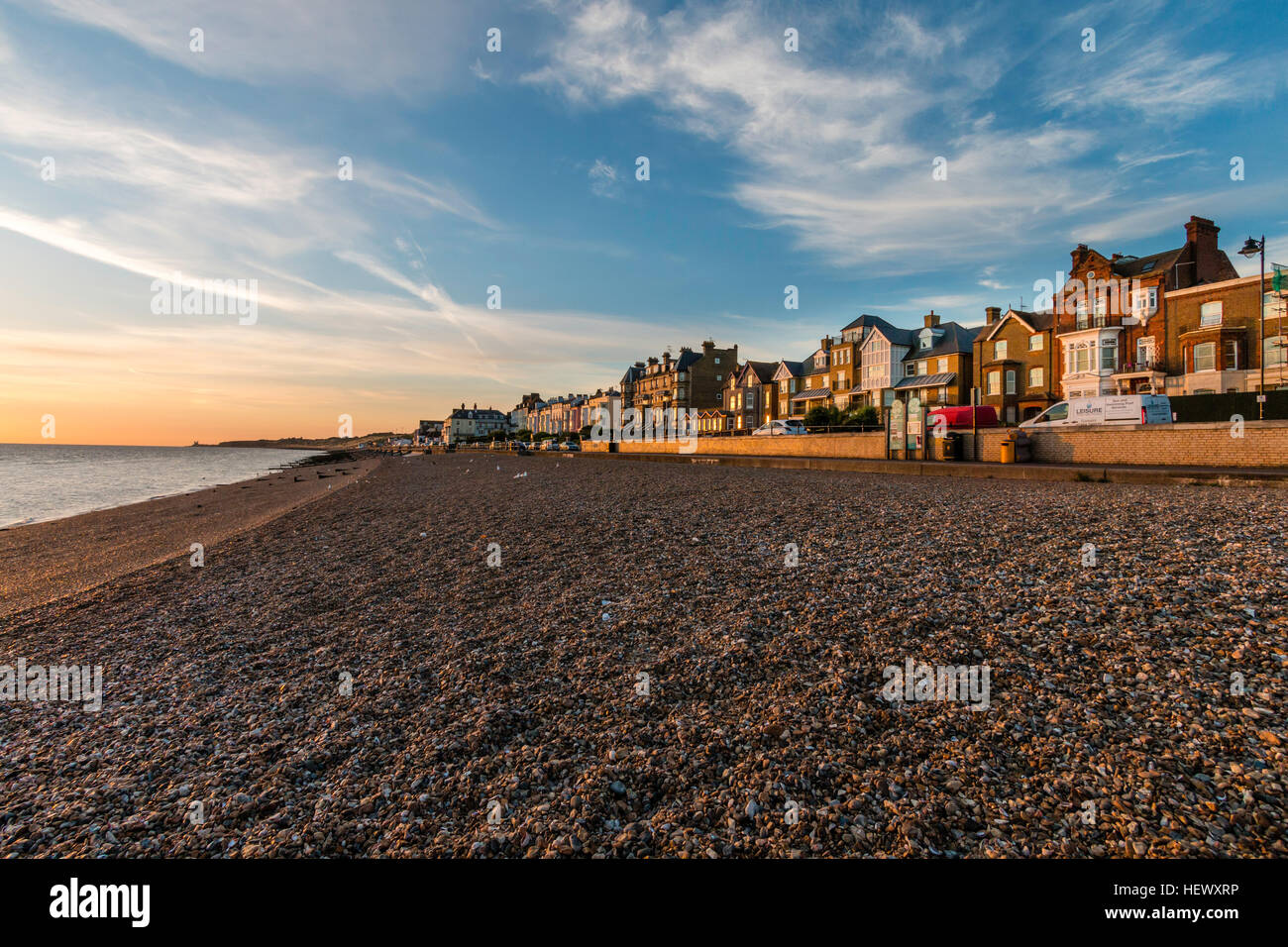 View along shingle beach with seafront promenade and town during ...