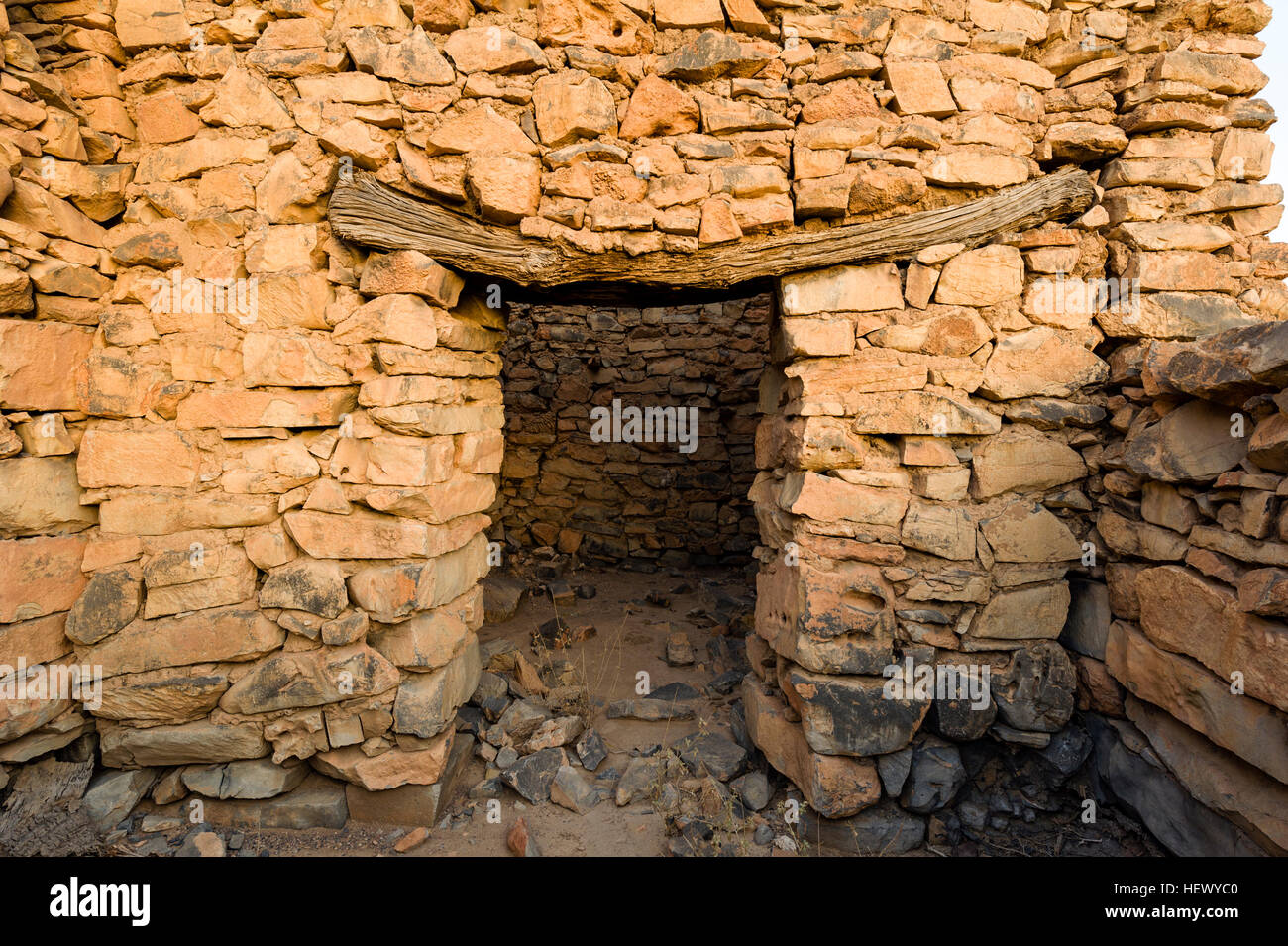An ancient handmade stone building wall and timber door lintel in an ...