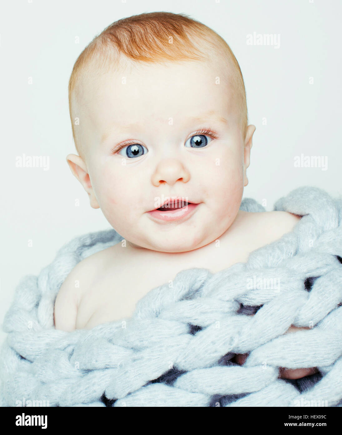 little cute red head baby in scarf all over him close up isolate Stock ...