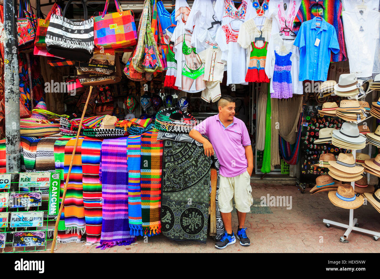 Shopkeeper selling clothing, hats and other souvenirs at a shop on 5th ...