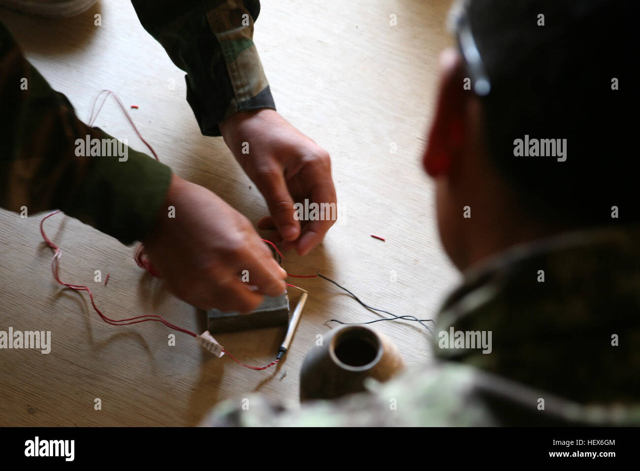 An Afghan National Army soldier watches a classmate examine the wiring ...