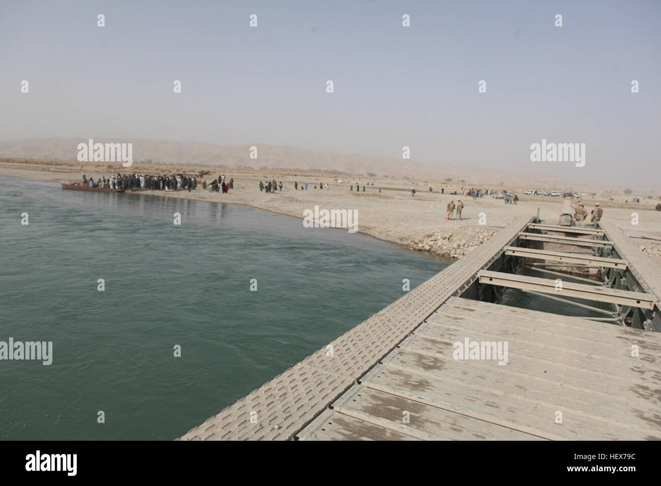 Crowds of Afghan locals use a ferryman to cross the Helmand River as ...