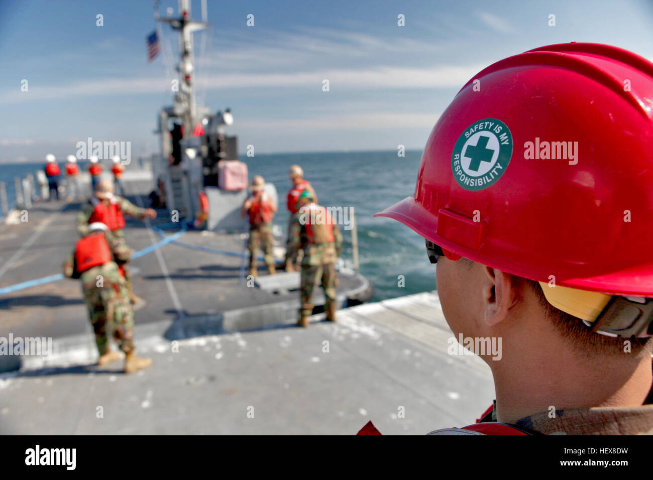 U.S. Navy sailors with Amphibious Construction Battalion One watches an ...