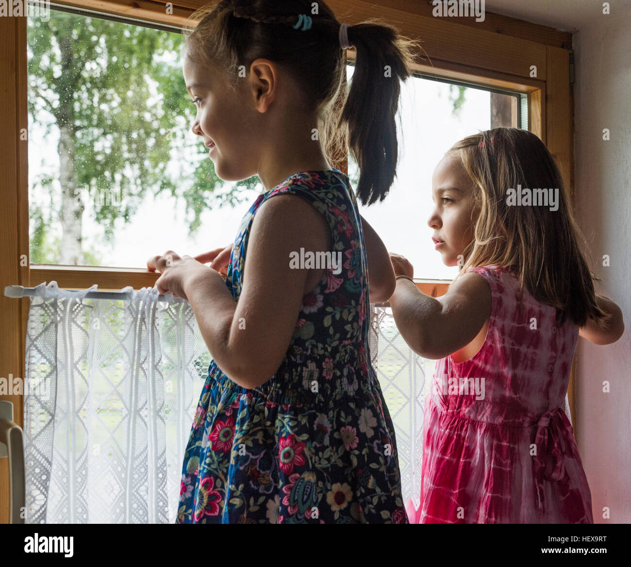 Girls looking out of window Stock Photo - Alamy