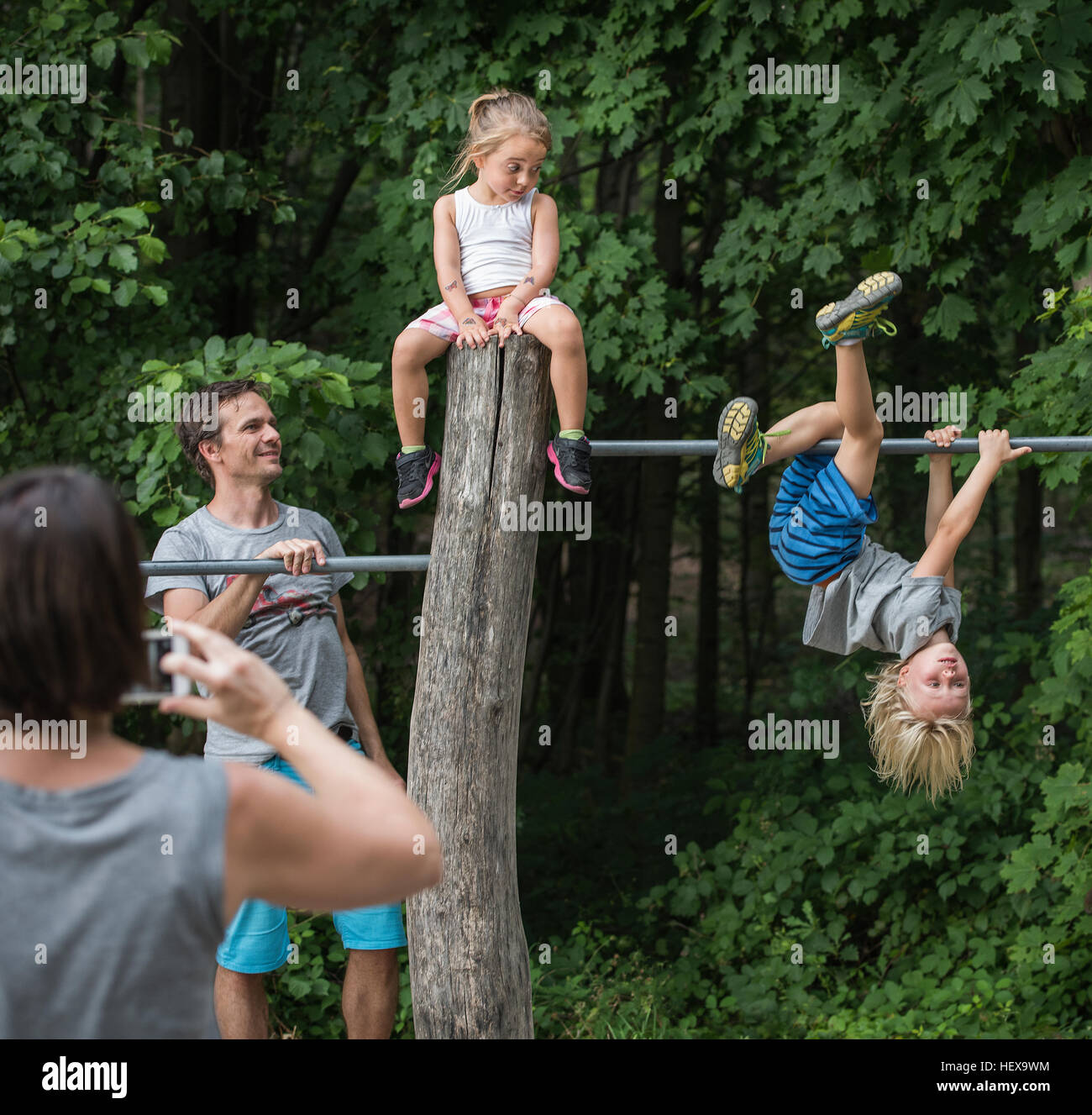 Mother photographing children playing on monkey bar Stock Photo - Alamy